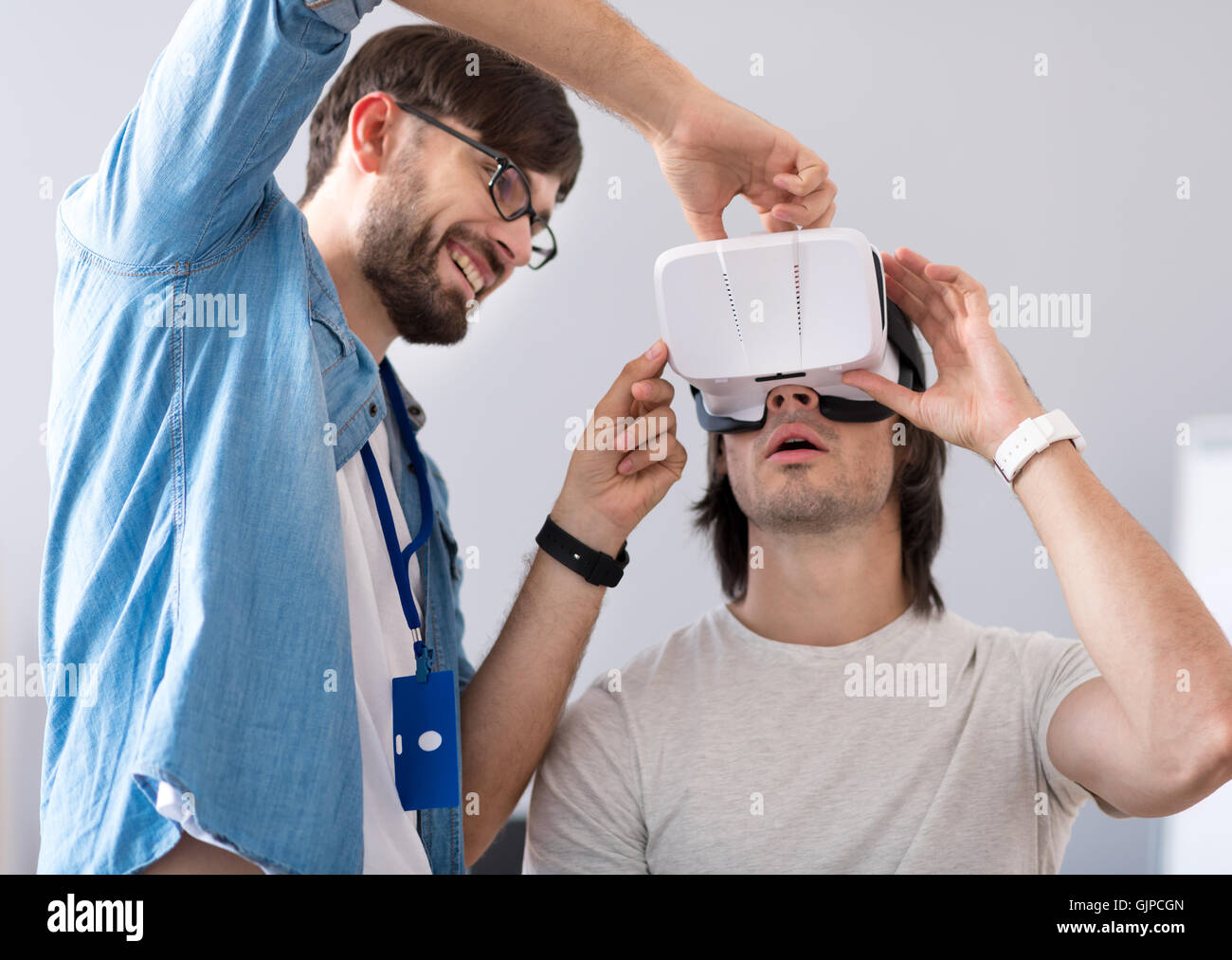 Positive colleagues testing virtual reality device Stock Photo - Alamy