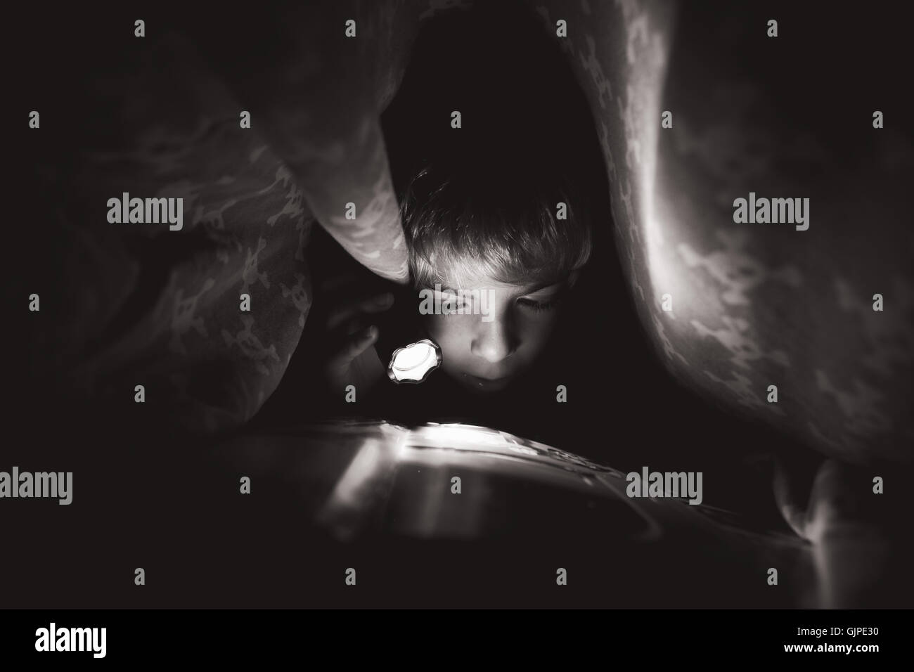 Child reading under bed sheets Stock Photo - Alamy