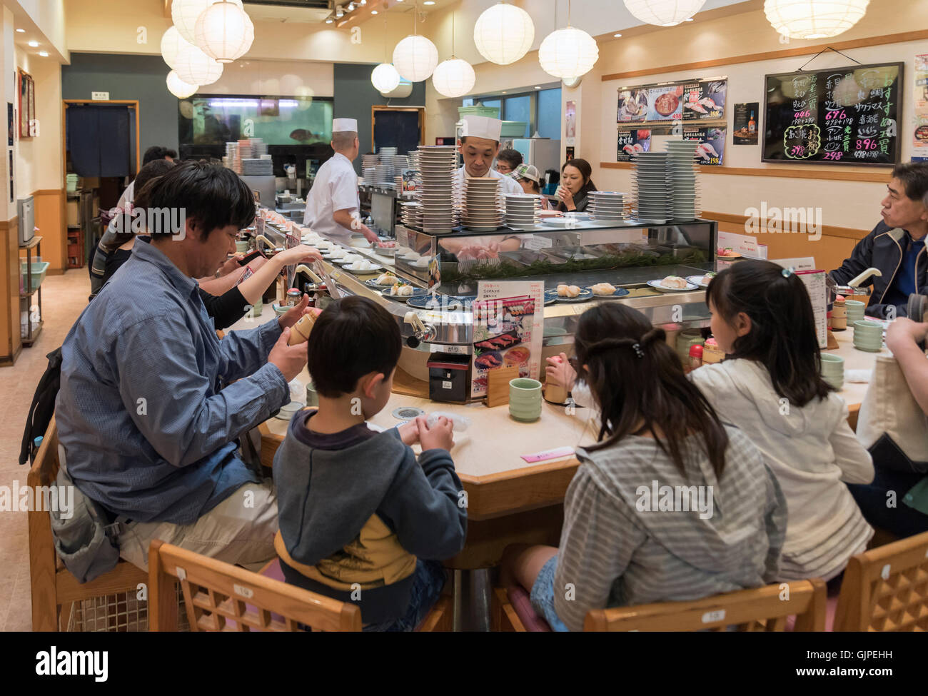 Kaiten-zushi restaurant serving sushi on rotating conveyor belt ...