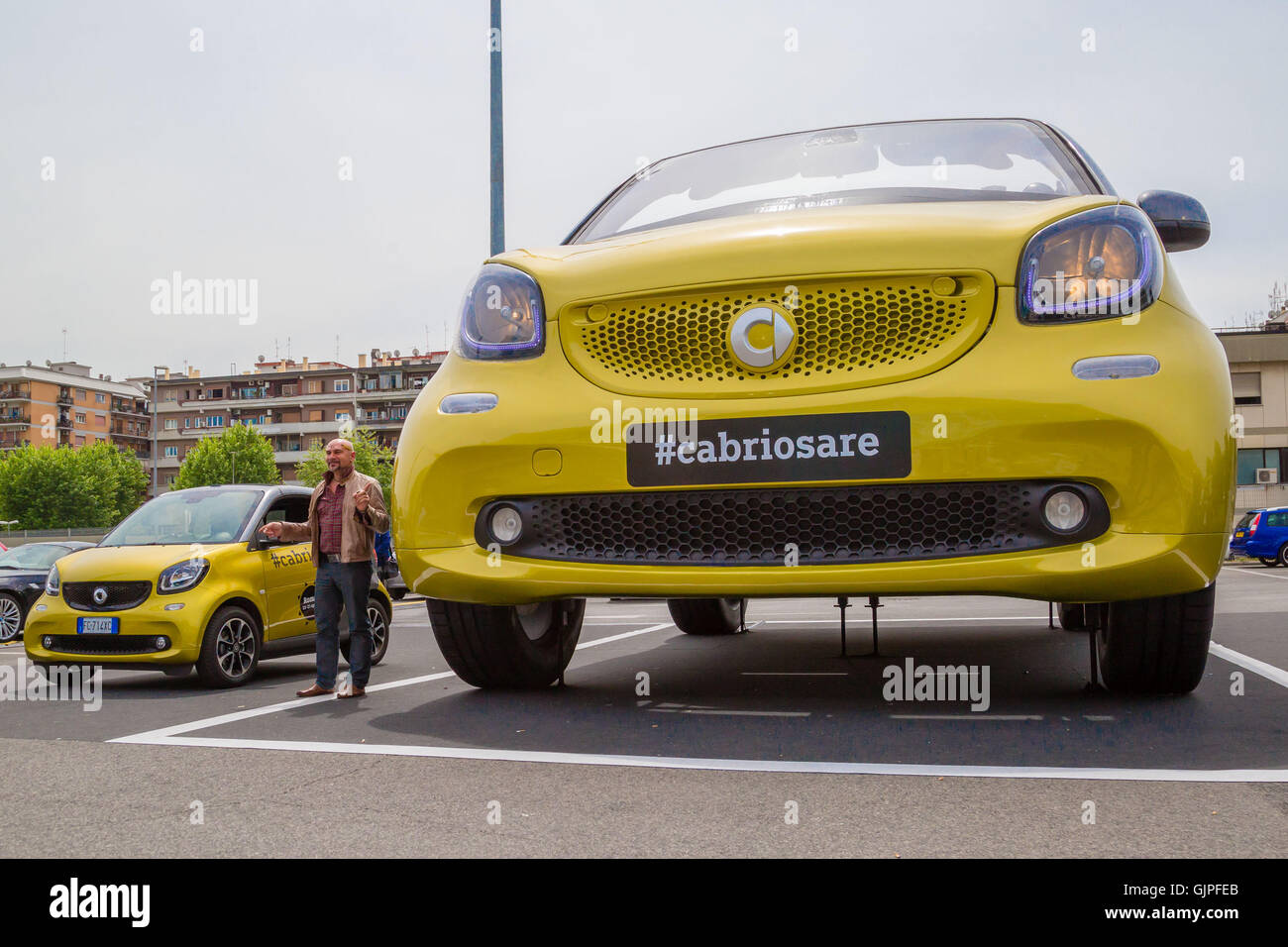 A giant Smart car next to a standard size Smart car in Rome Featuring ...