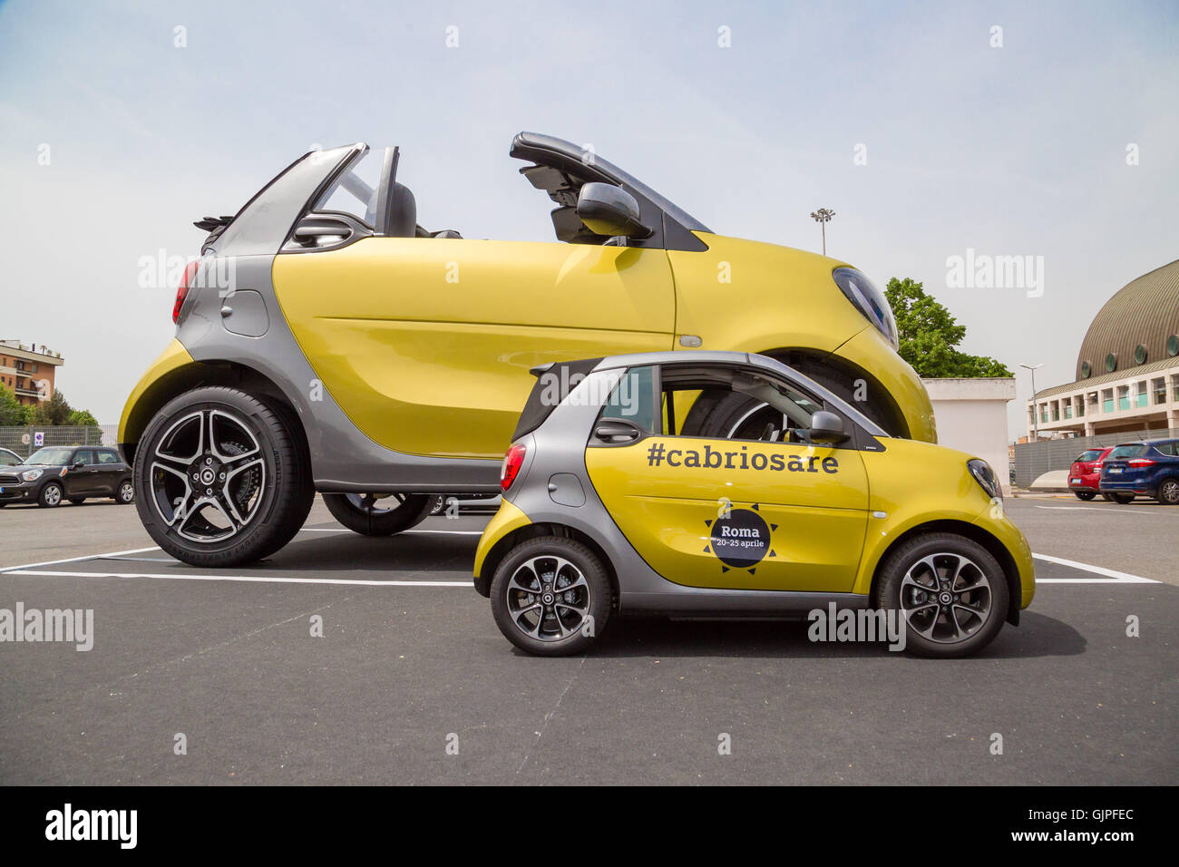 A giant Smart car next to a standard size Smart car in Rome Featuring ...