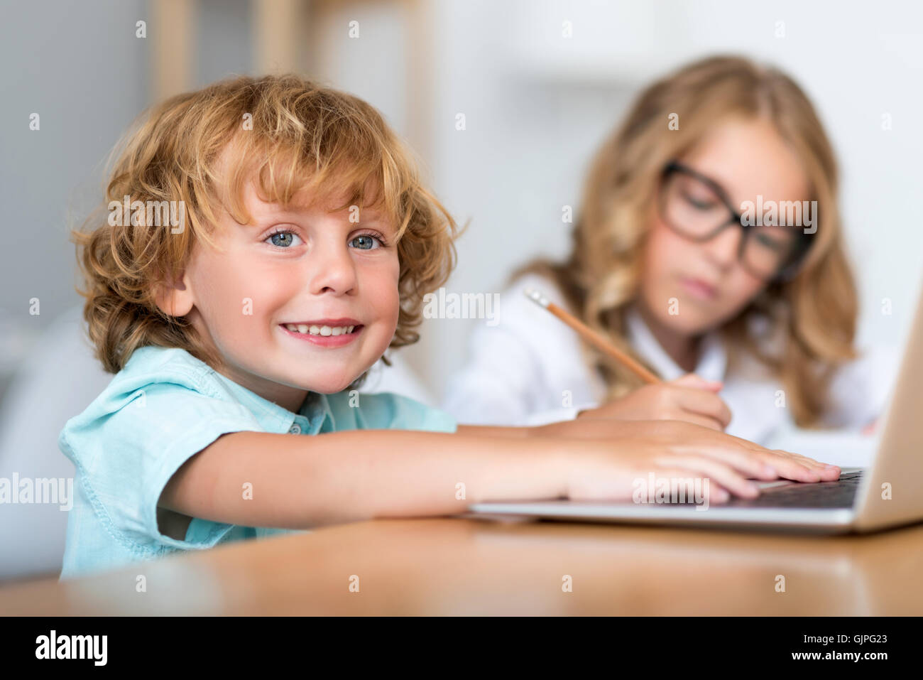 Smiling boy working on laptop Stock Photo - Alamy