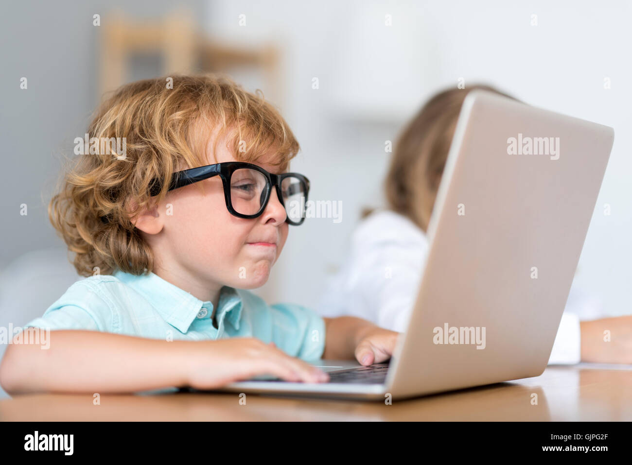 Boy with glasses working on laptop Stock Photo - Alamy