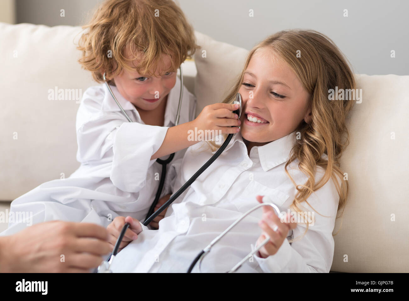 Cheerful boy putting stethoscope on cheek Stock Photo - Alamy