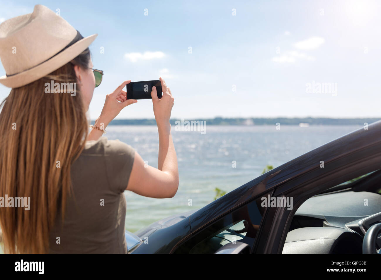 Pleasant woman taking pictures of the sea Stock Photo - Alamy