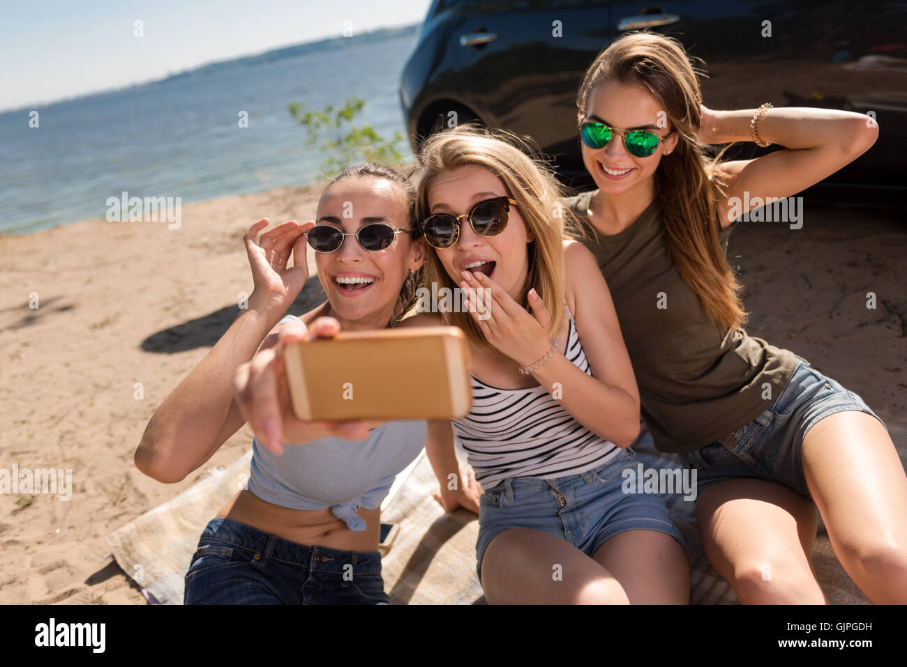 Positive friends making selfies Stock Photo - Alamy
