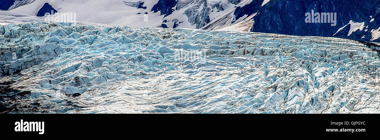A glacier sweeps down a mountain valley Stock Photo - Alamy