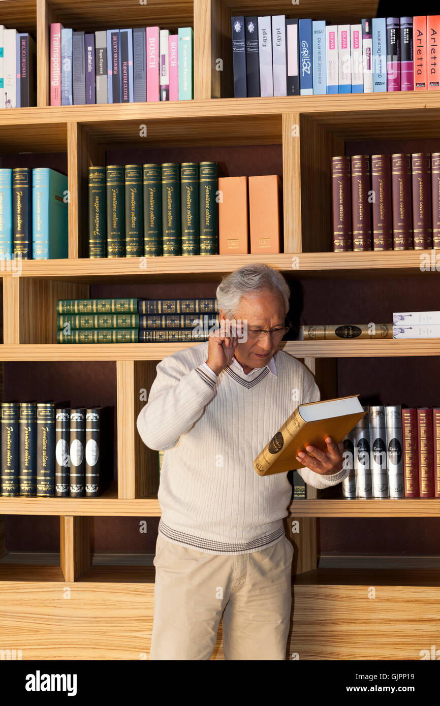Old man reading a book in the library Stock Photo - Alamy
