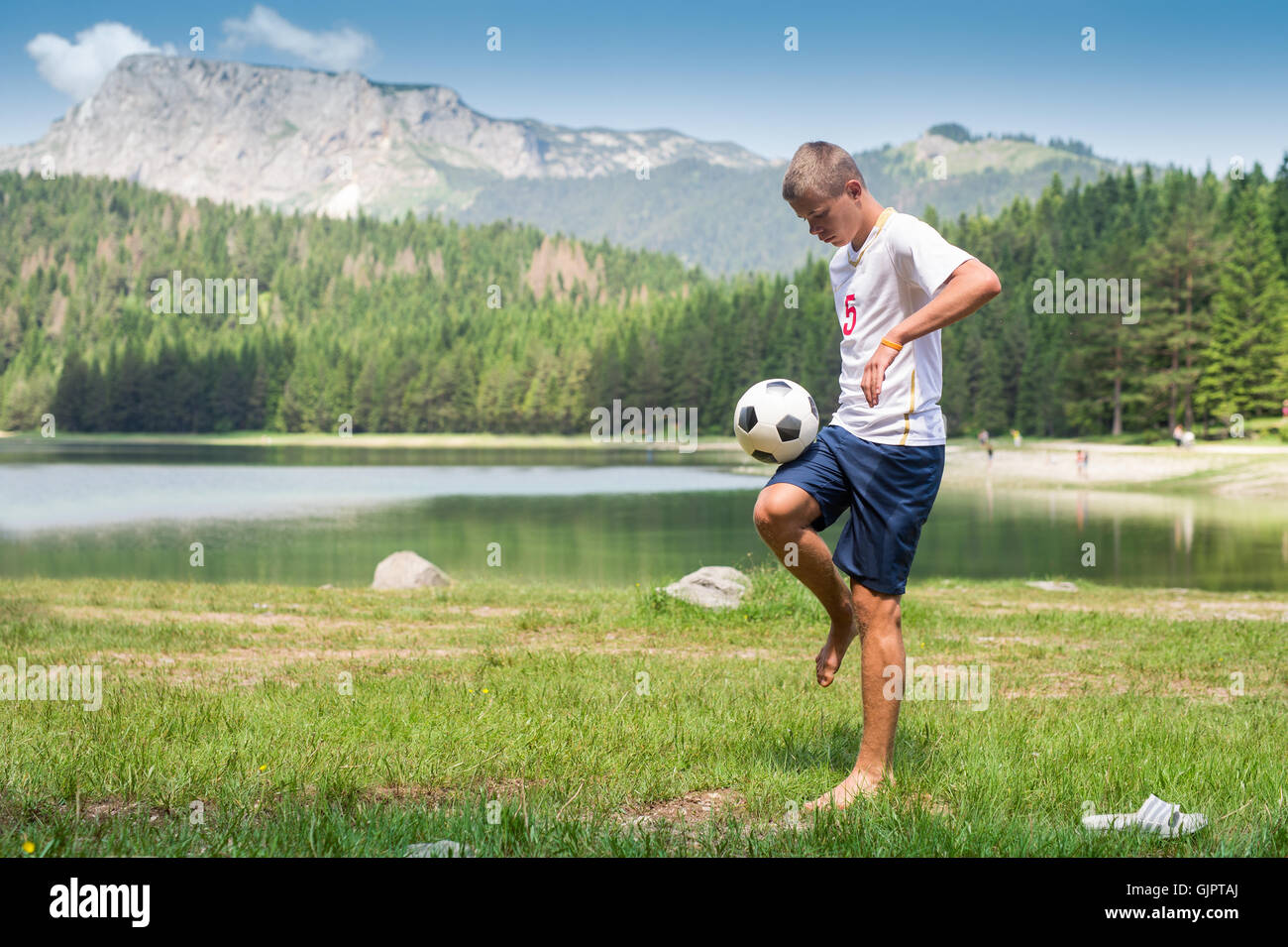 Soccer player juggles the ball in nature Stock Photo - Alamy
