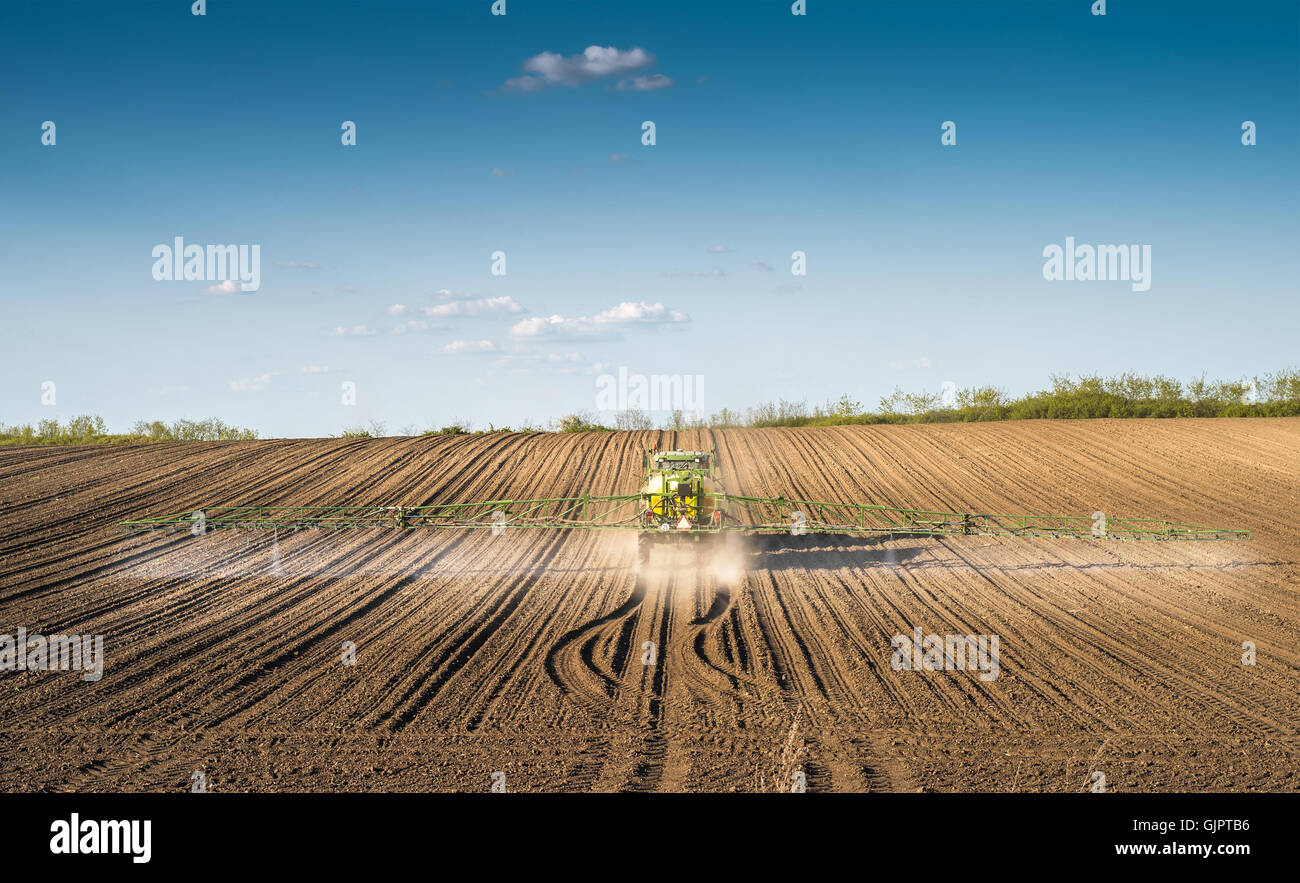 Tractor spraying on field Stock Photo - Alamy
