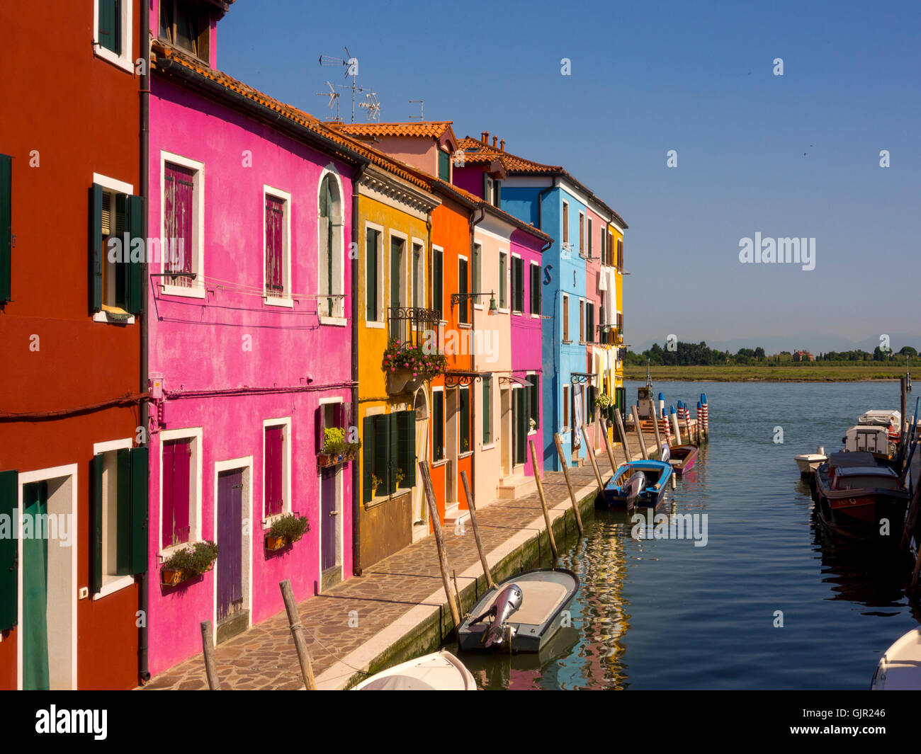 Brightly painted canalside terrace houses on the island of Burano ...