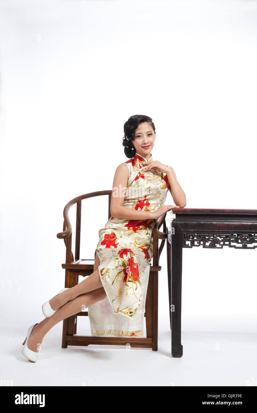 Dressed in traditional Chinese costumes studio shot young woman sitting ...