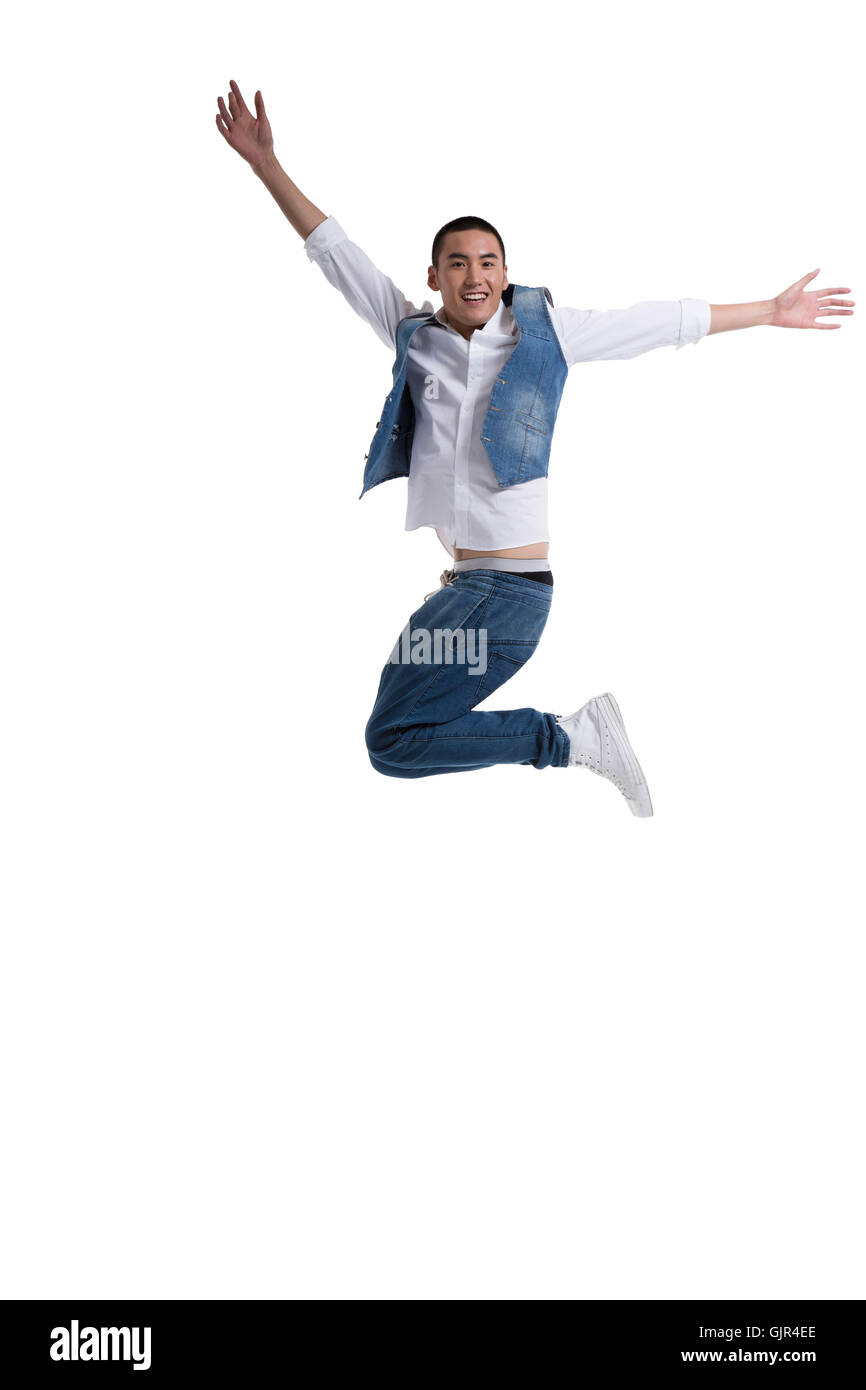 Studio shot Young casual man jumping Stock Photo - Alamy