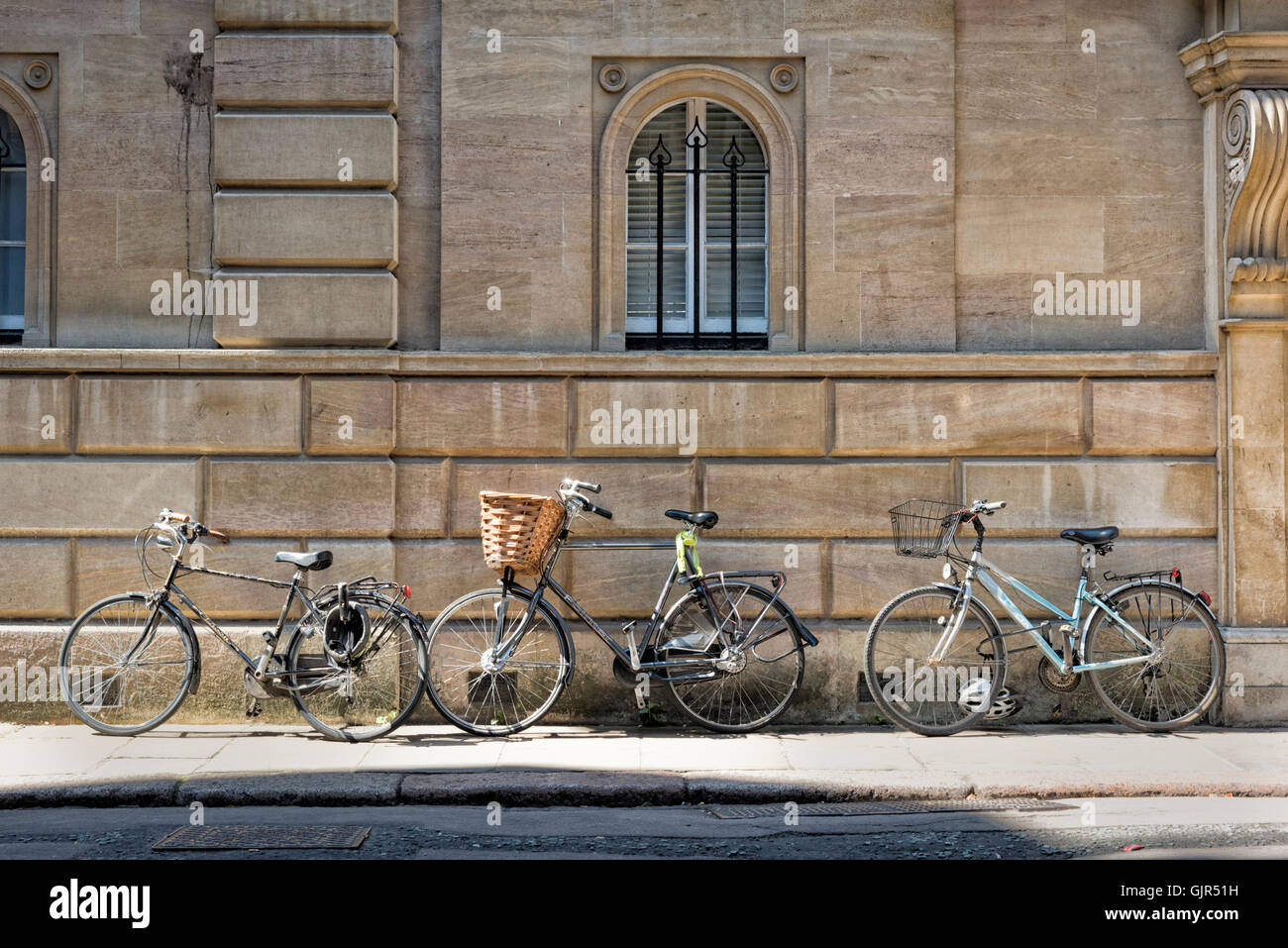 Traditional bicycle with basket leaning against the old stone wall of a ...