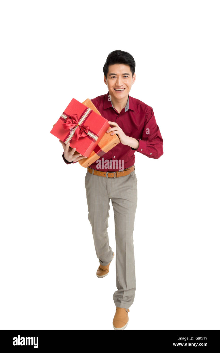 Studio shot Young man holding a gift box Stock Photo - Alamy