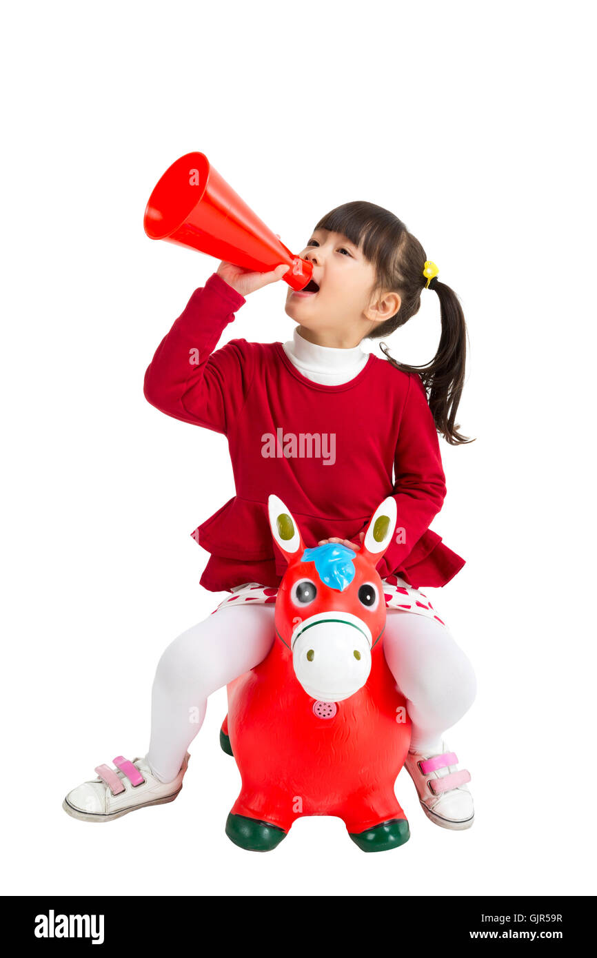 Studio shot little girl riding a pony trumpet Stock Photo - Alamy