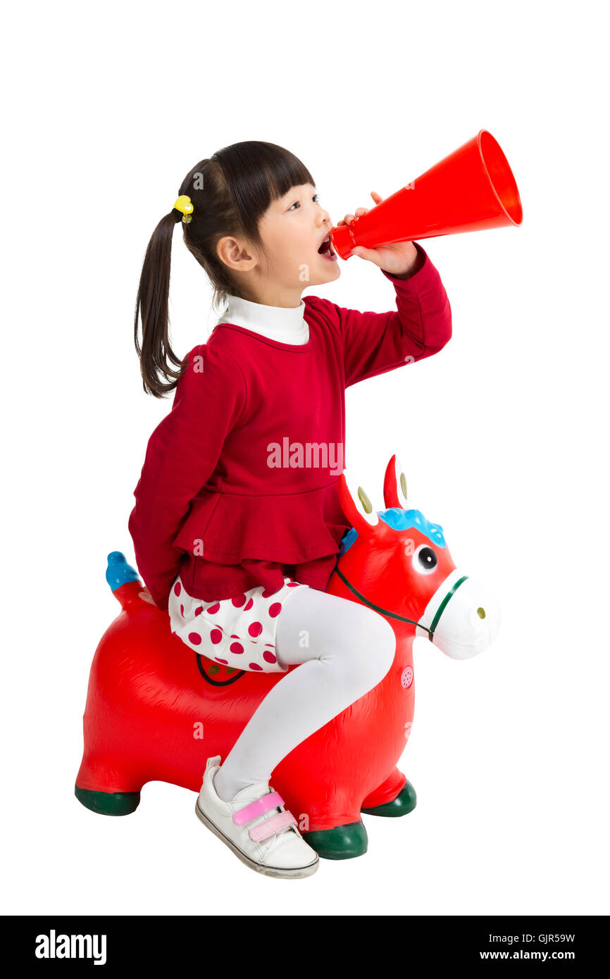 Studio shot little girl riding a pony trumpet Stock Photo - Alamy
