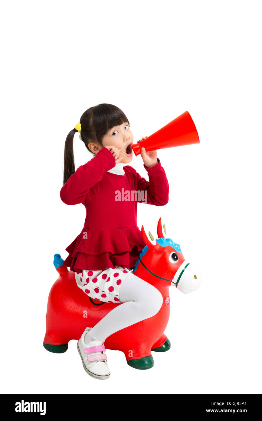 Studio shot little girl riding a pony trumpet Stock Photo - Alamy