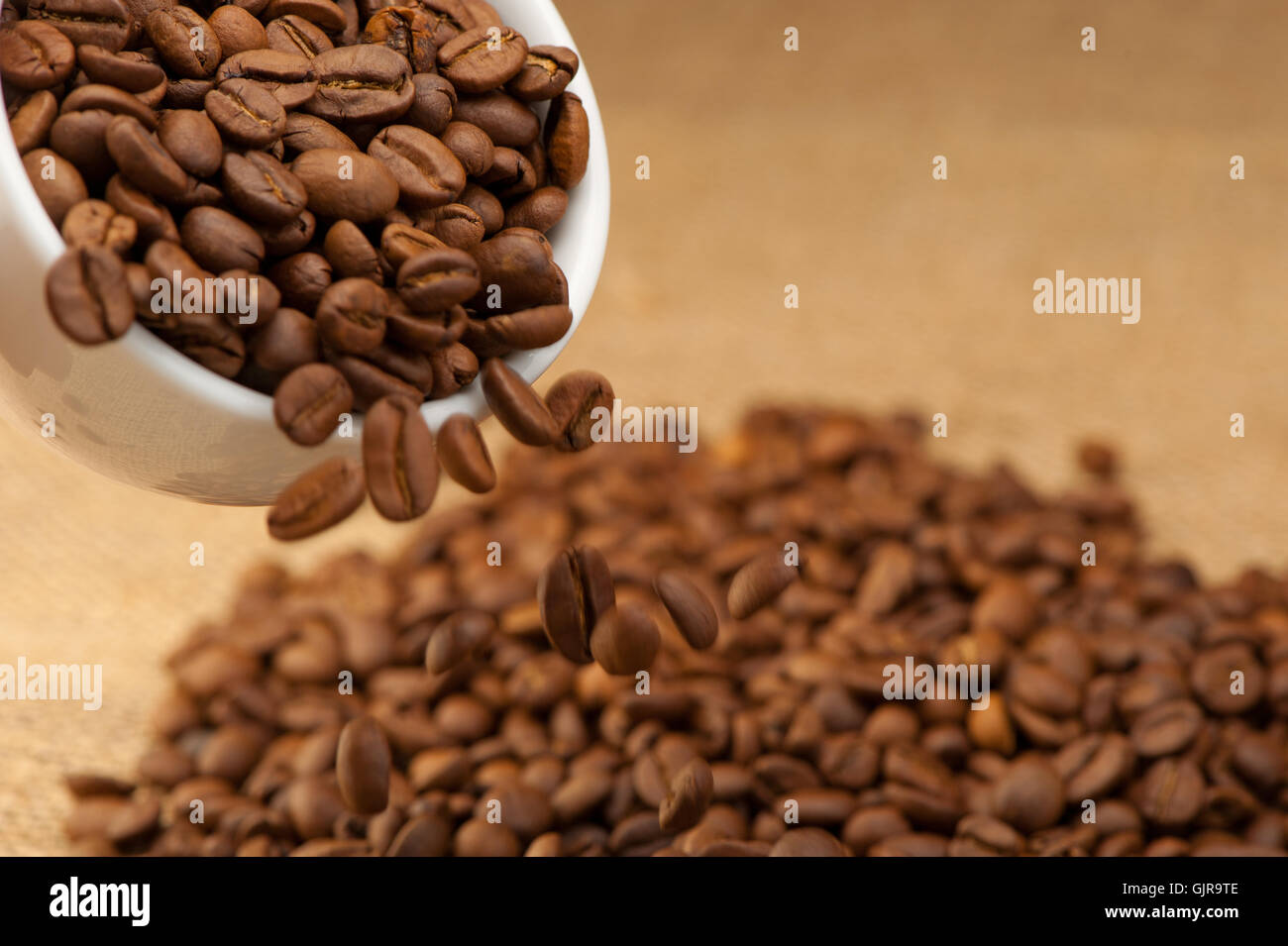 Coffee grains fall from a cup Stock Photo - Alamy