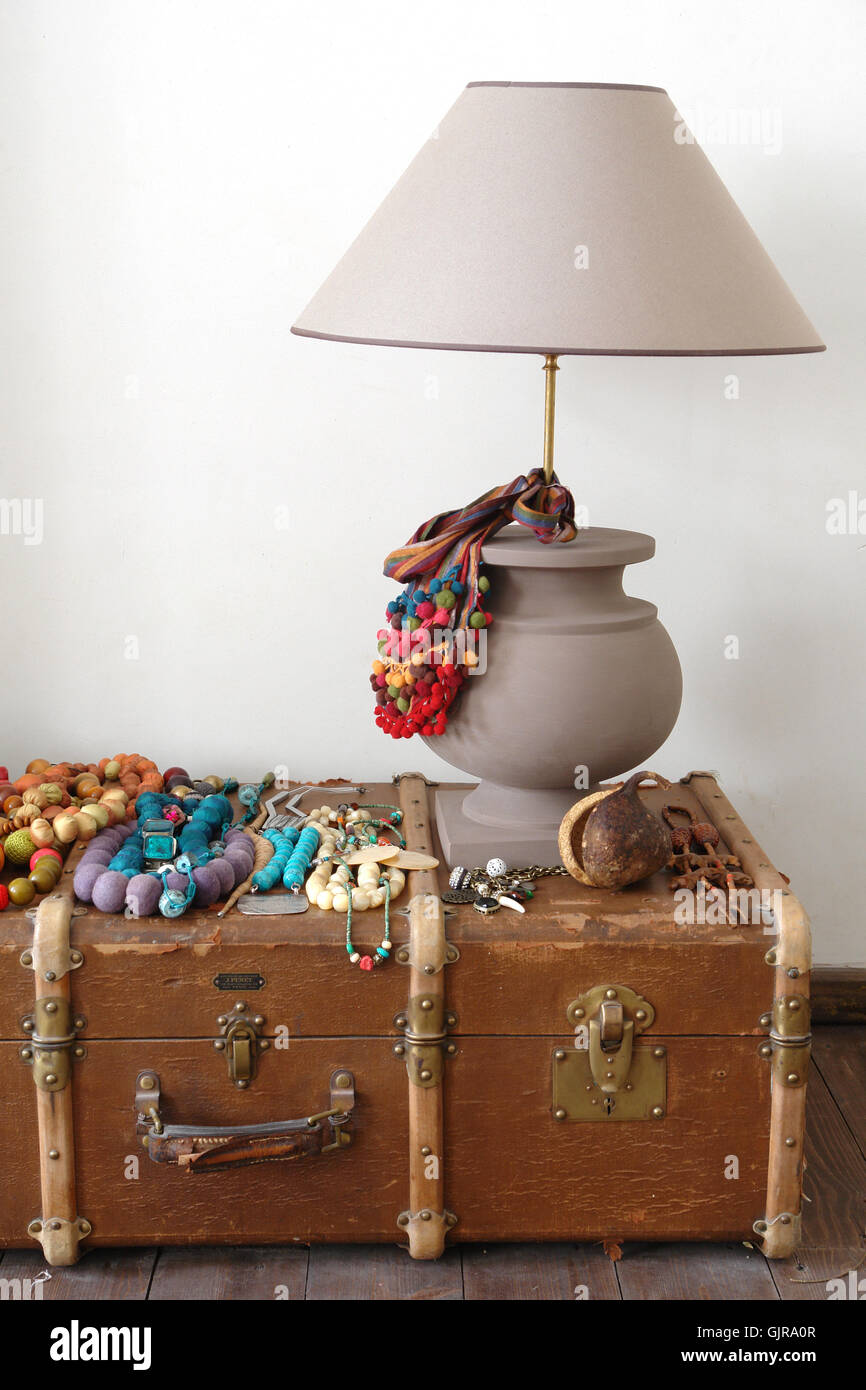 lamp, beads and old suitcase on the floor Stock Photo - Alamy