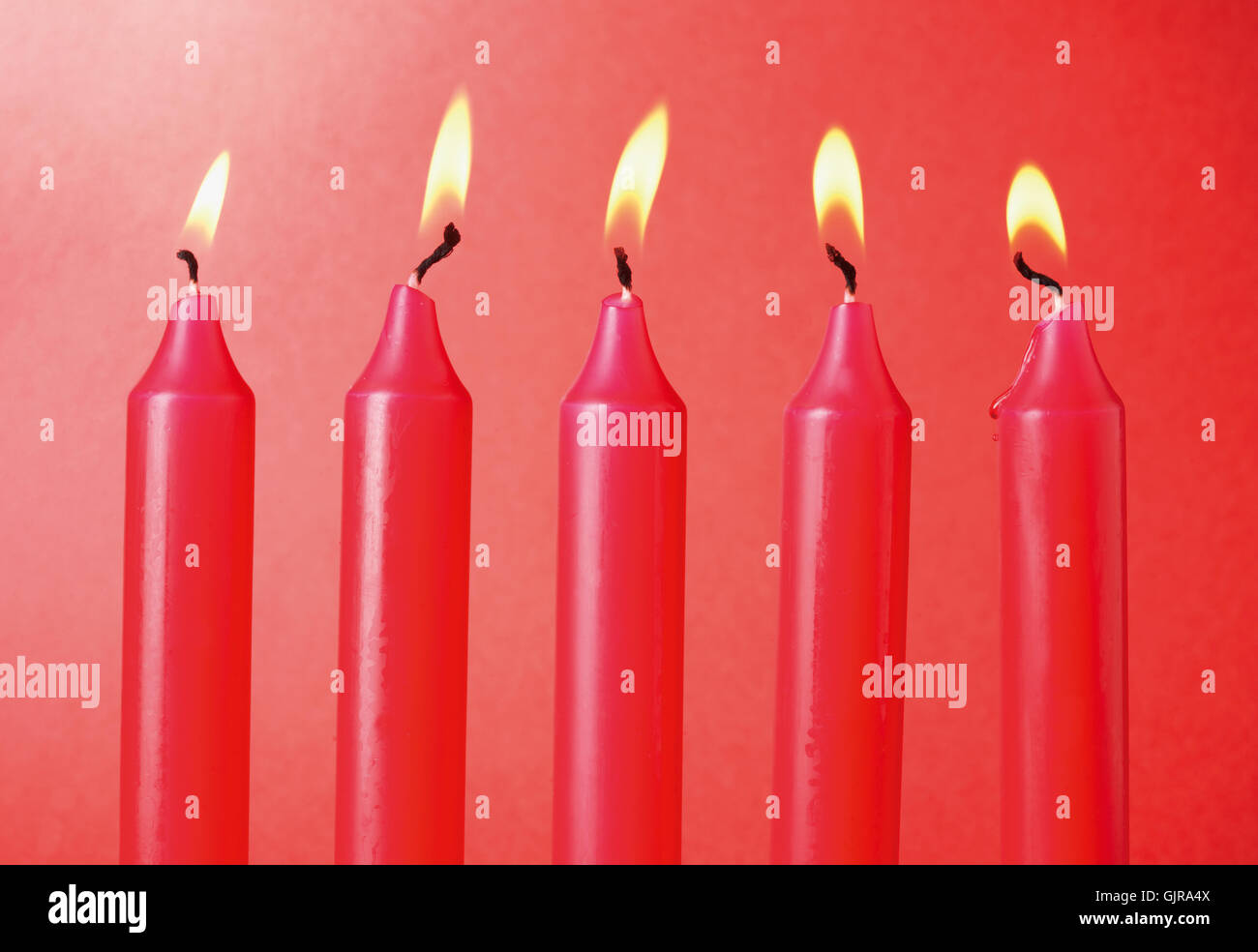Five Red Candles on red background Stock Photo - Alamy