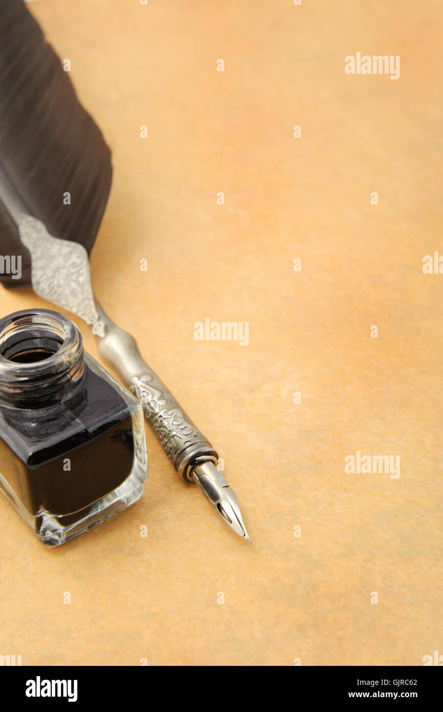 Feather quill and inkwell on an old paper Stock Photo - Alamy