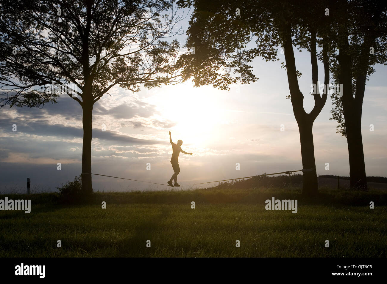 young man on the slackline in the sunset Stock Photo - Alamy
