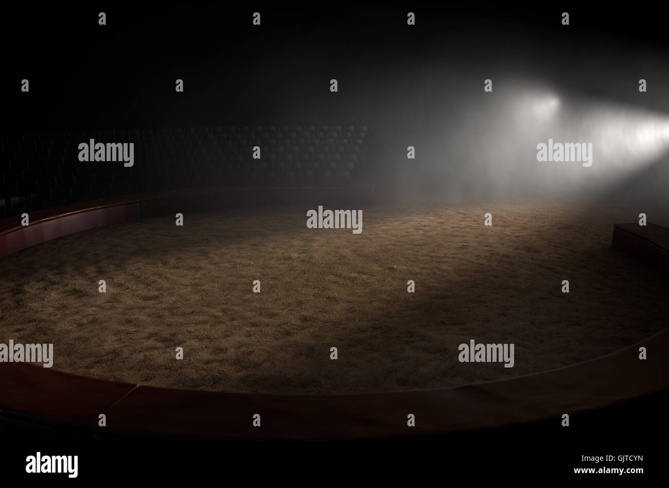 A 3D render of an empty classic circus arena back lit by dramatic spot ...