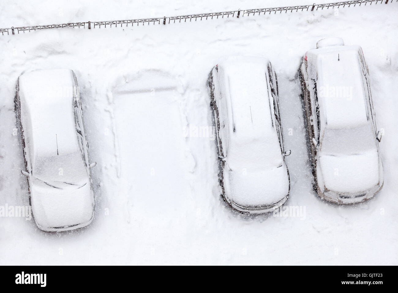 Covering with snow line of standing car with free parking place, winter ...