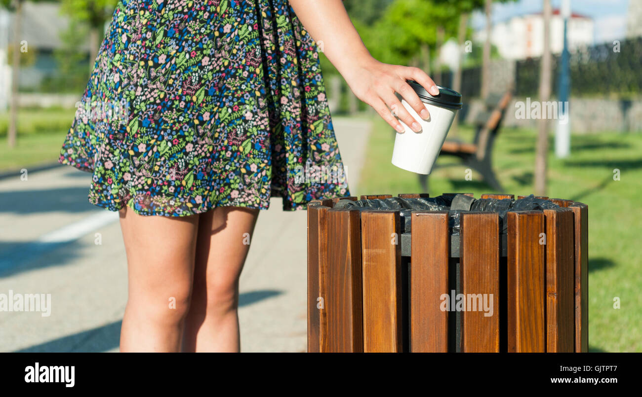 Young female hand throwing paper cup on trash bin outside in park Stock ...