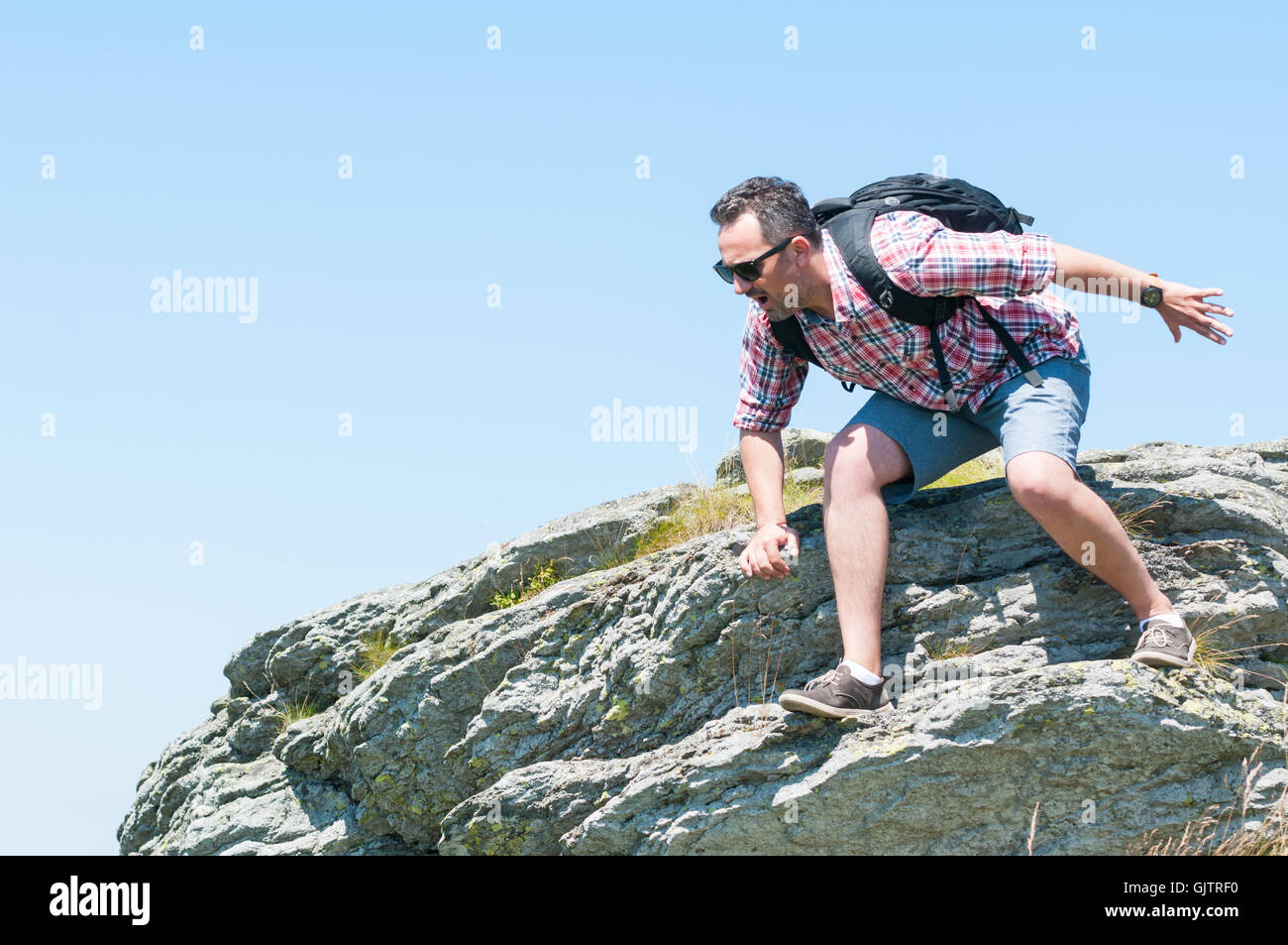 Male backpacker falling or jumping from cliff outside on top of the ...