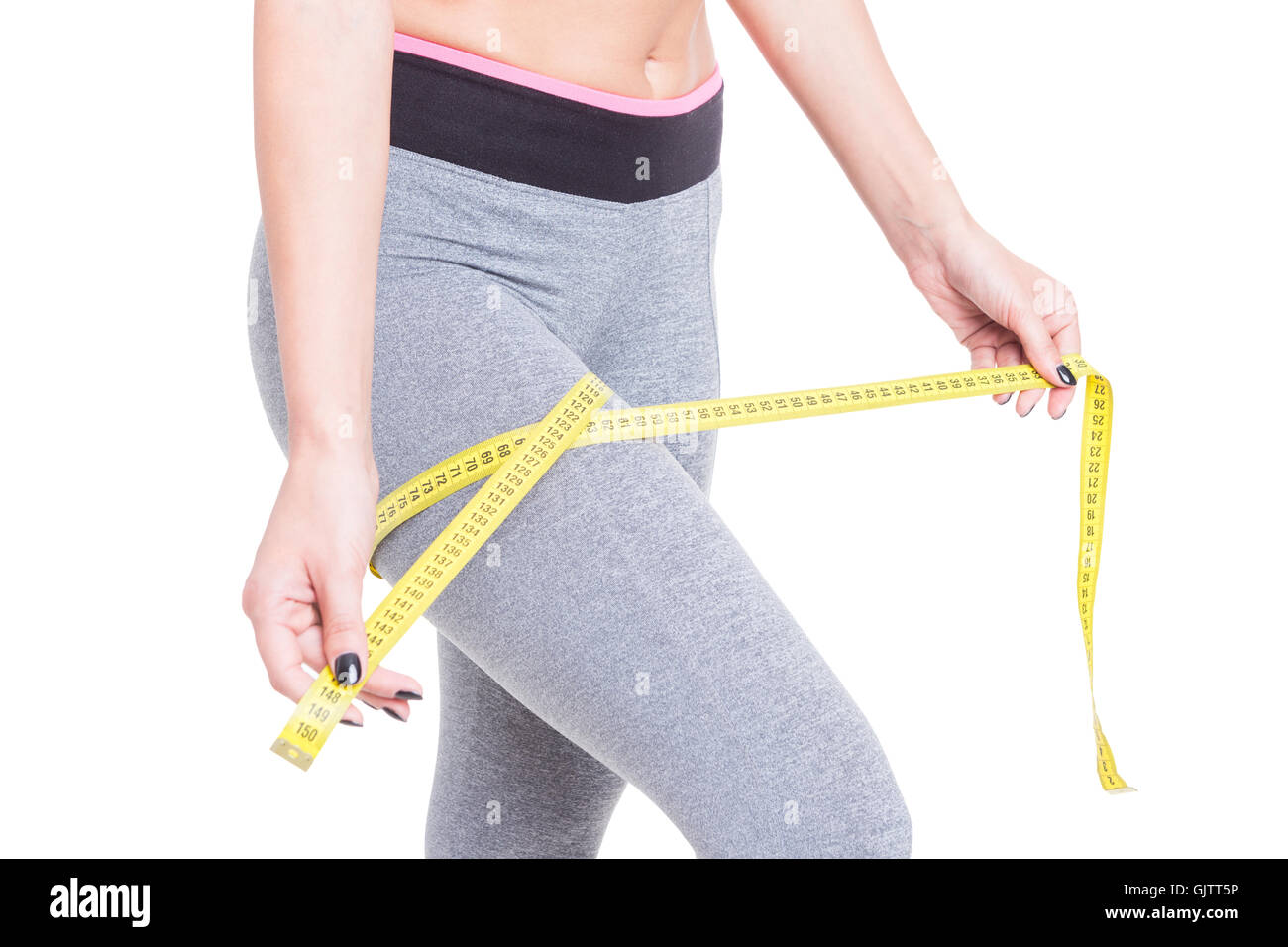 Close-up of female measuring her leg with yellow tape line isolated on ...