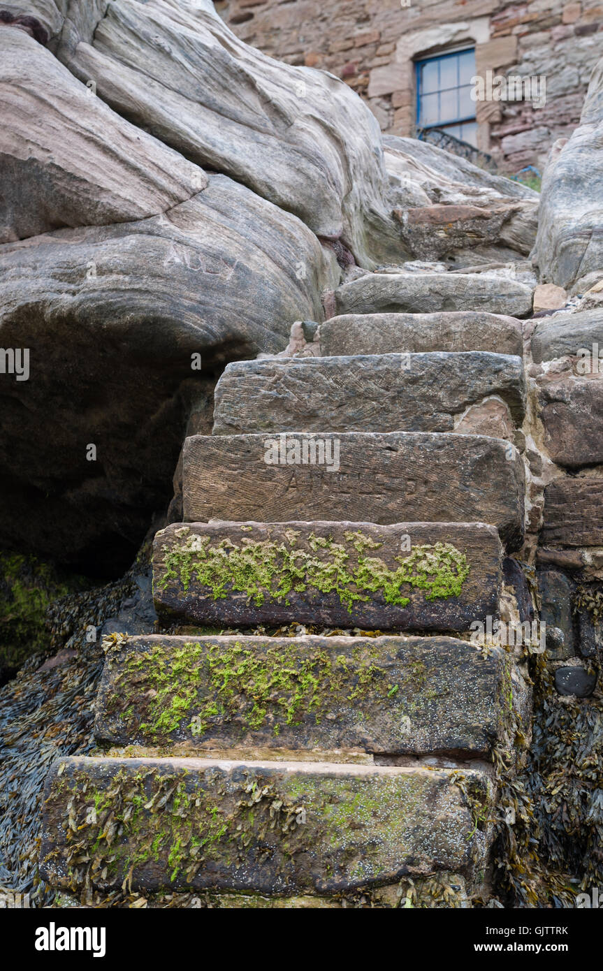 a flight of very old stone steps leading through the rocks up to an old ...