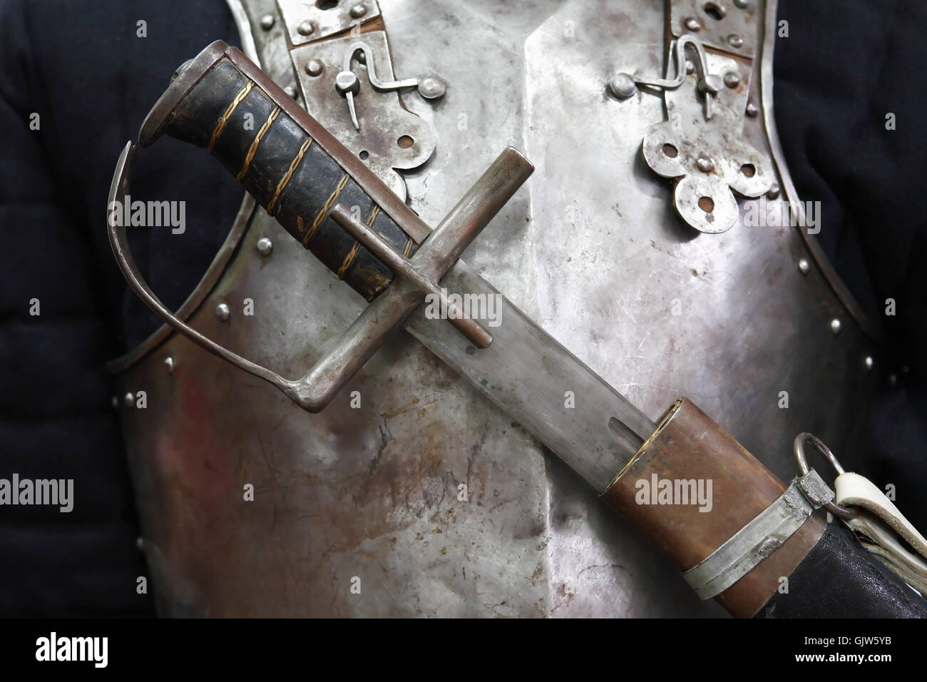 Ancient saber closeup on metal armour background Stock Photo - Alamy