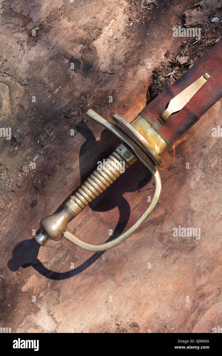 Closeup of ancient saber on gray old wooden log Stock Photo - Alamy