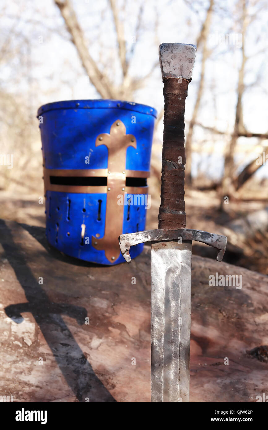 Ancient Teutonic sword against wooden log with metal helmet Stock Photo ...