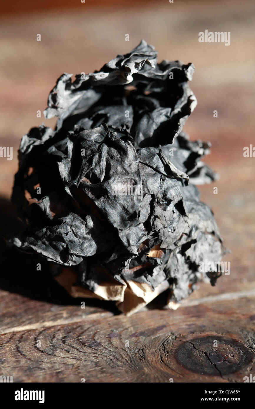 Closeup of black paper ashes on wooden background Stock Photo - Alamy
