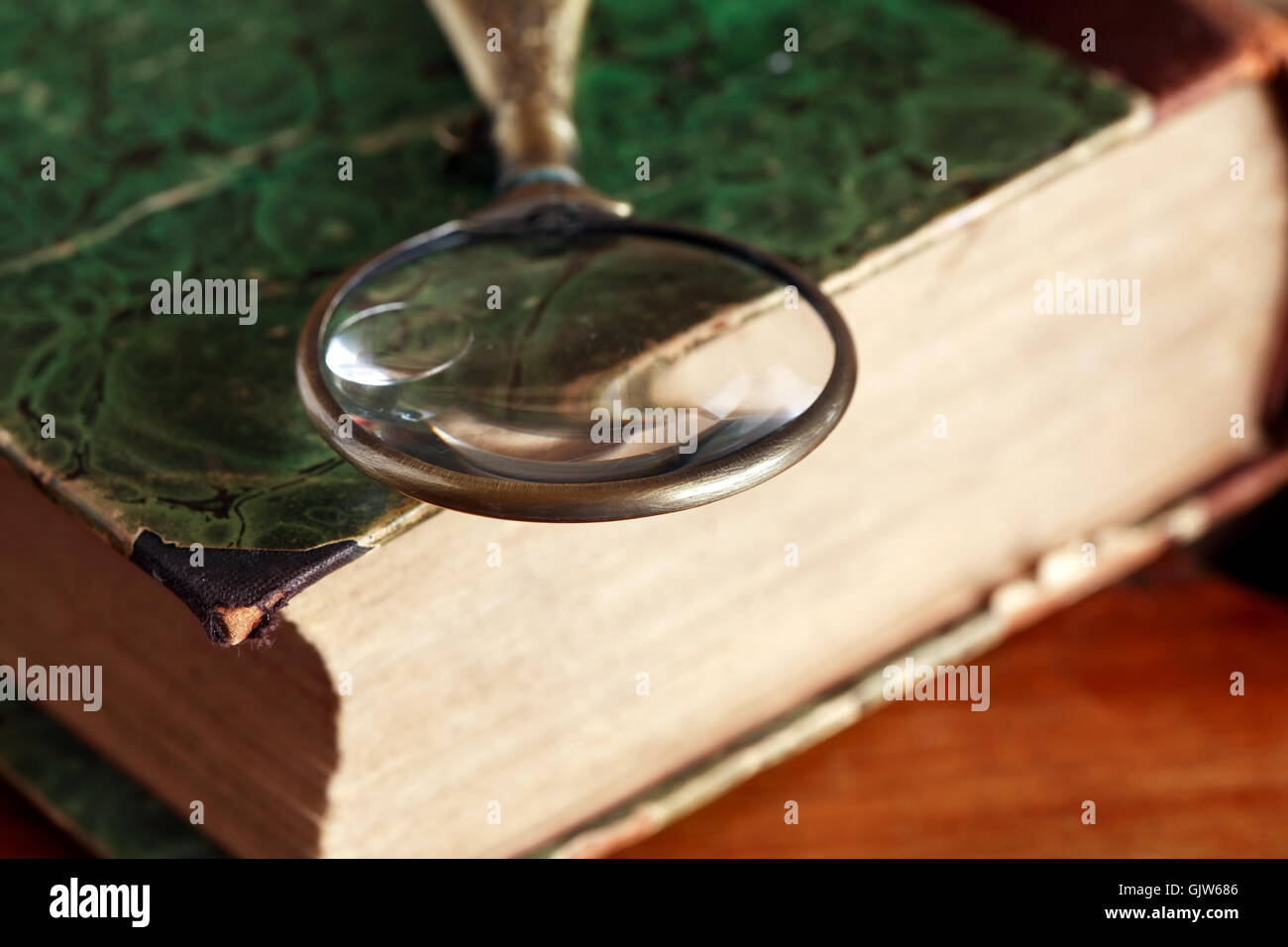 Closeup of vintage magnifying glass lying on old book Stock Photo - Alamy