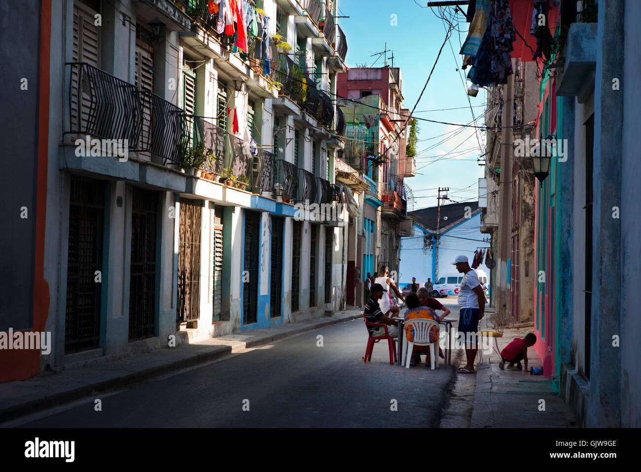 a typical cuban gathering of a few neighbours over a table game taking ...