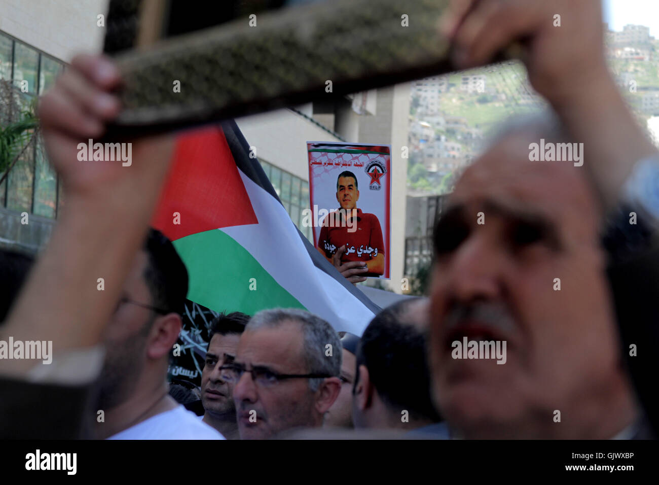 West Bank, Palestine. 18th Aug, 2016. Palestinians hold pictures of ...