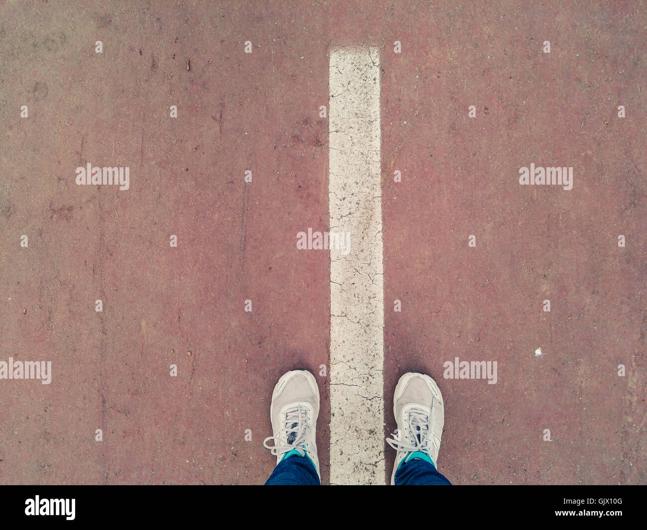 Standing between the pedestrian line on red sidewalk Stock Photo - Alamy