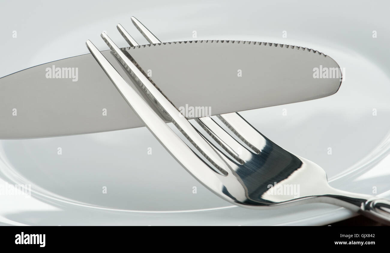 Knife and fork on a plate Stock Photo - Alamy