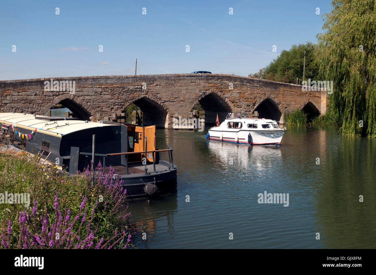 A cabin cruiser on the River Thames at Newbridge, Oxfordshire, England ...