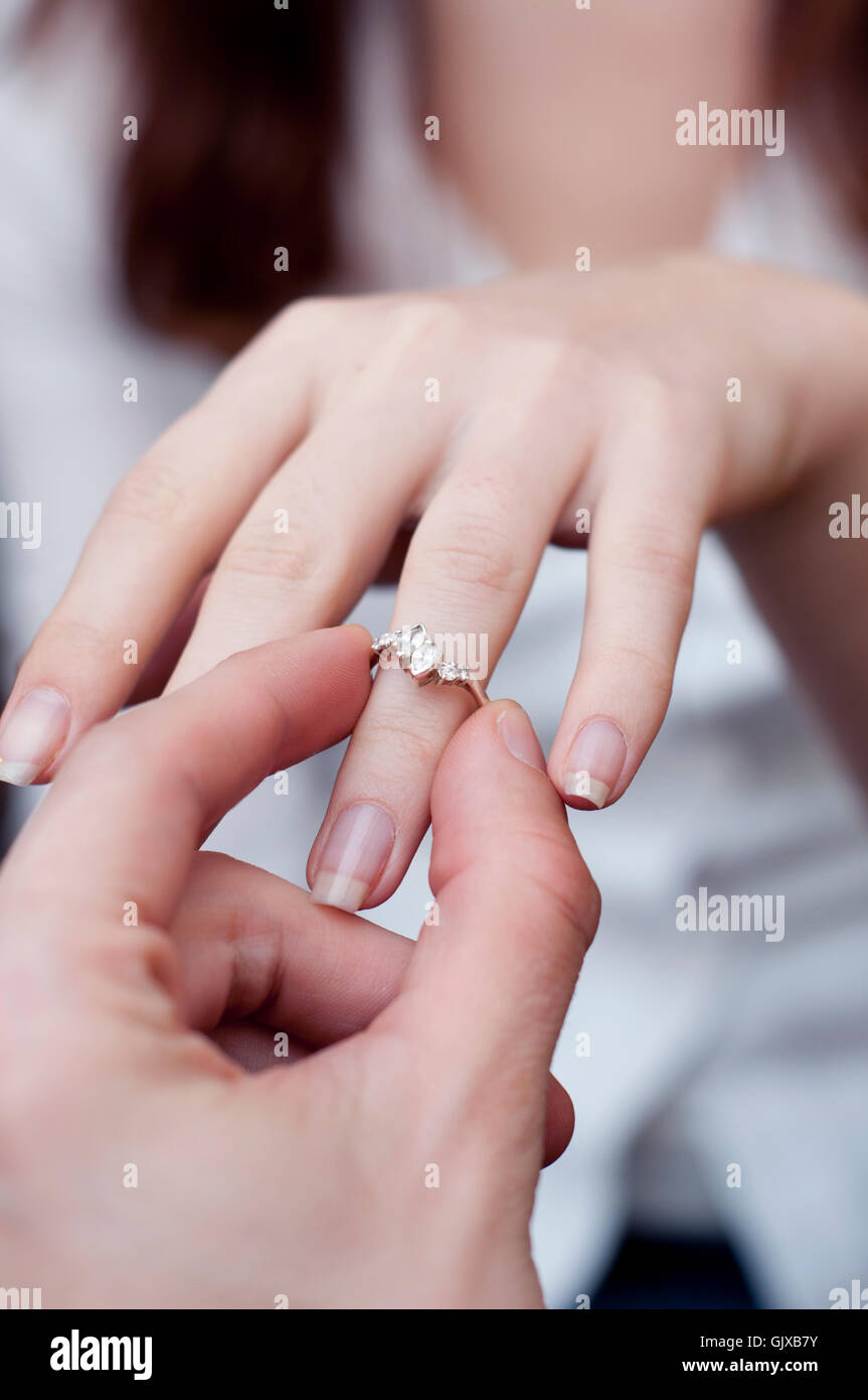situation of inserting engagement ring into a finger Stock Photo - Alamy