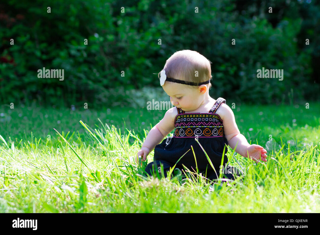 Baby girl at roughly 6 months old outdoors in a natural setting with ...