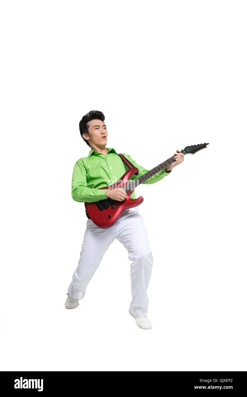 Fashion studio shot of young men while playing the guitar and dancing ...