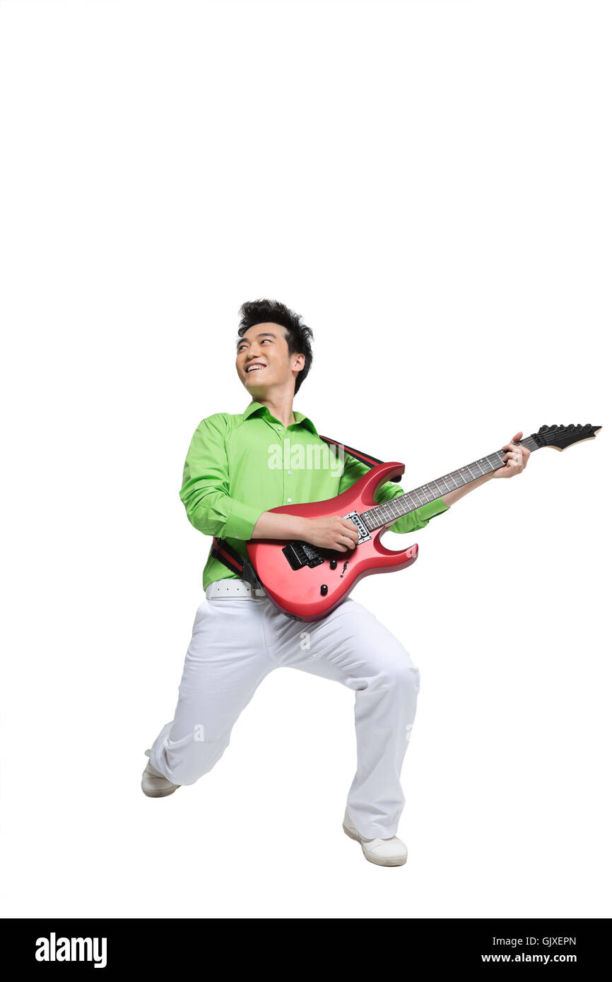Fashion studio shot of young men while playing the guitar and dancing ...