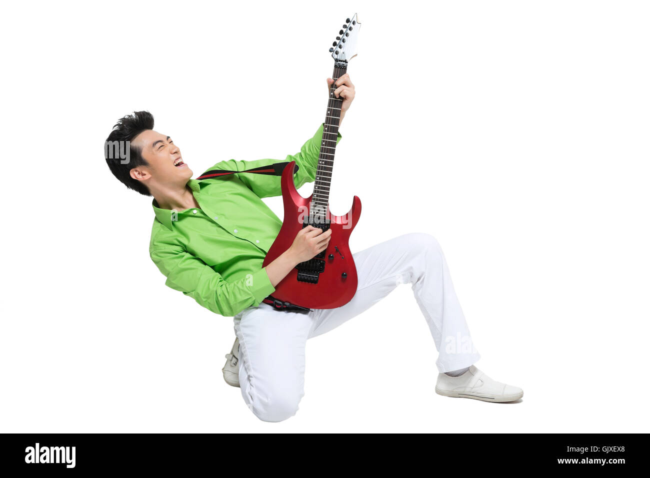 Fashion studio shot of young men while playing the guitar and dancing ...
