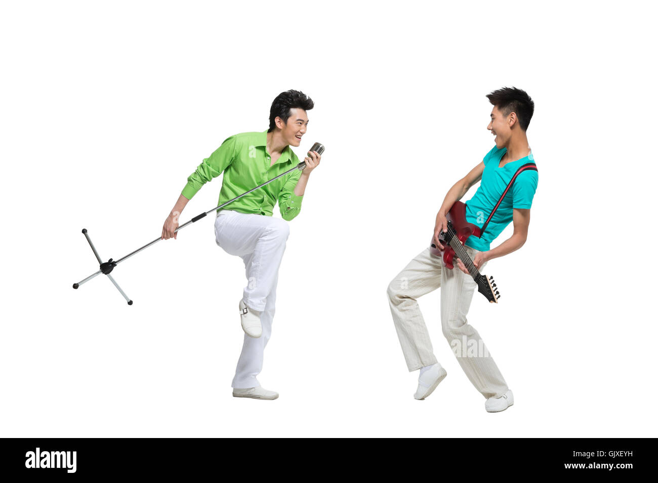 Fashion studio shot of young men while playing the guitar and dancing ...