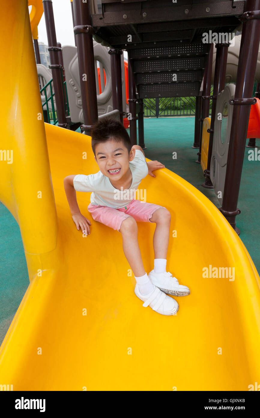 Little boy playing in kindergarten slides Stock Photo - Alamy